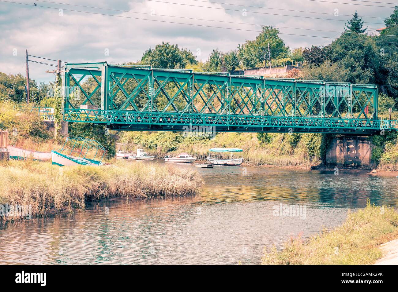 landscape of fishing boats on the river and big green steel bridge ...