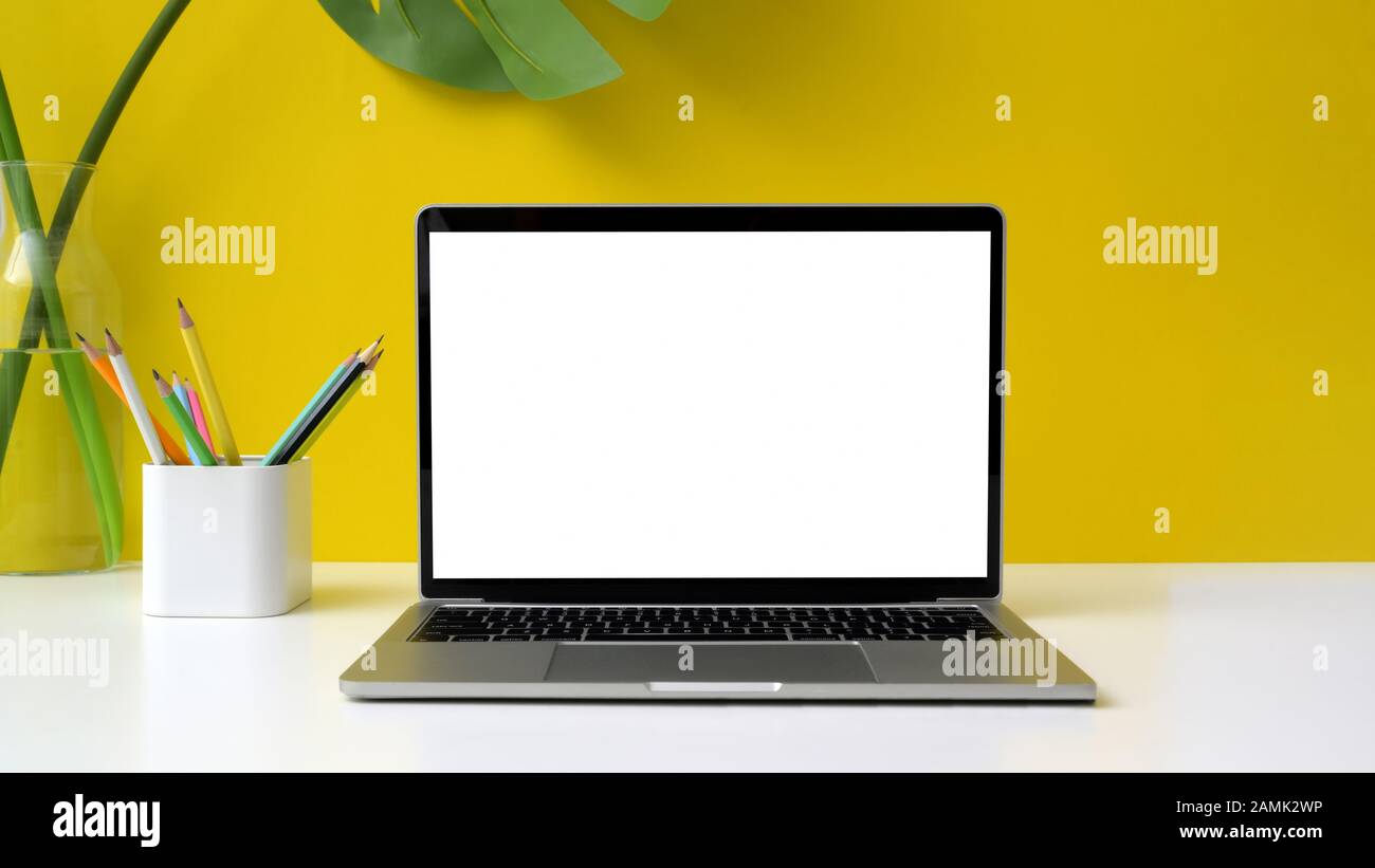 Close up view of colorful workspace with blank screen laptop, pencils ...