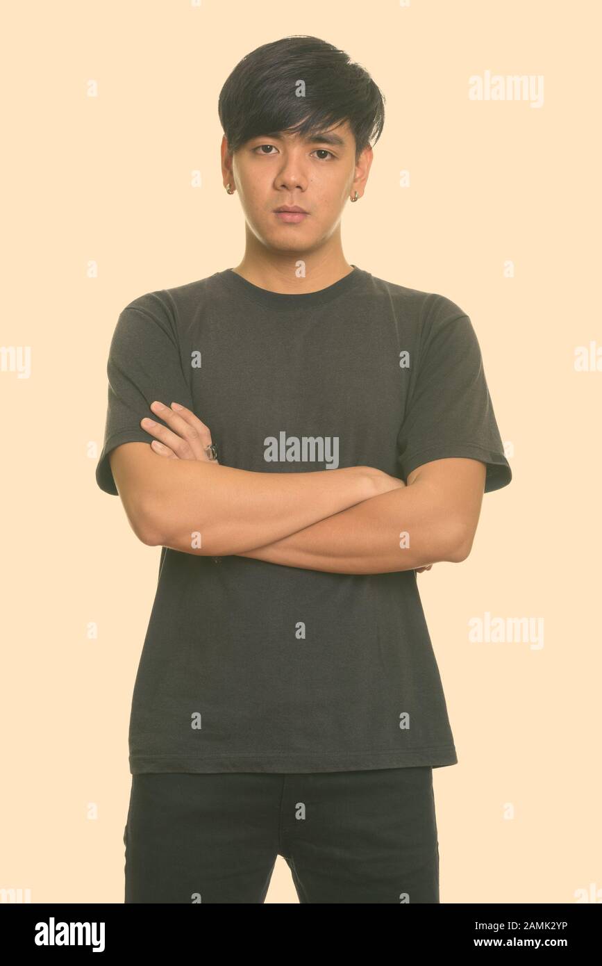 Studio shot of young handsome Filipino man isolated against white ...