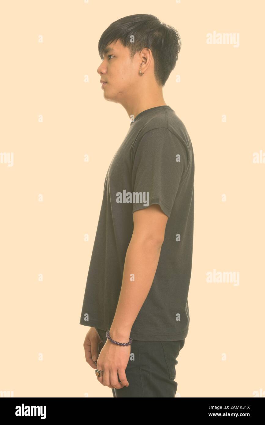 Studio shot of young handsome Filipino man isolated against white ...