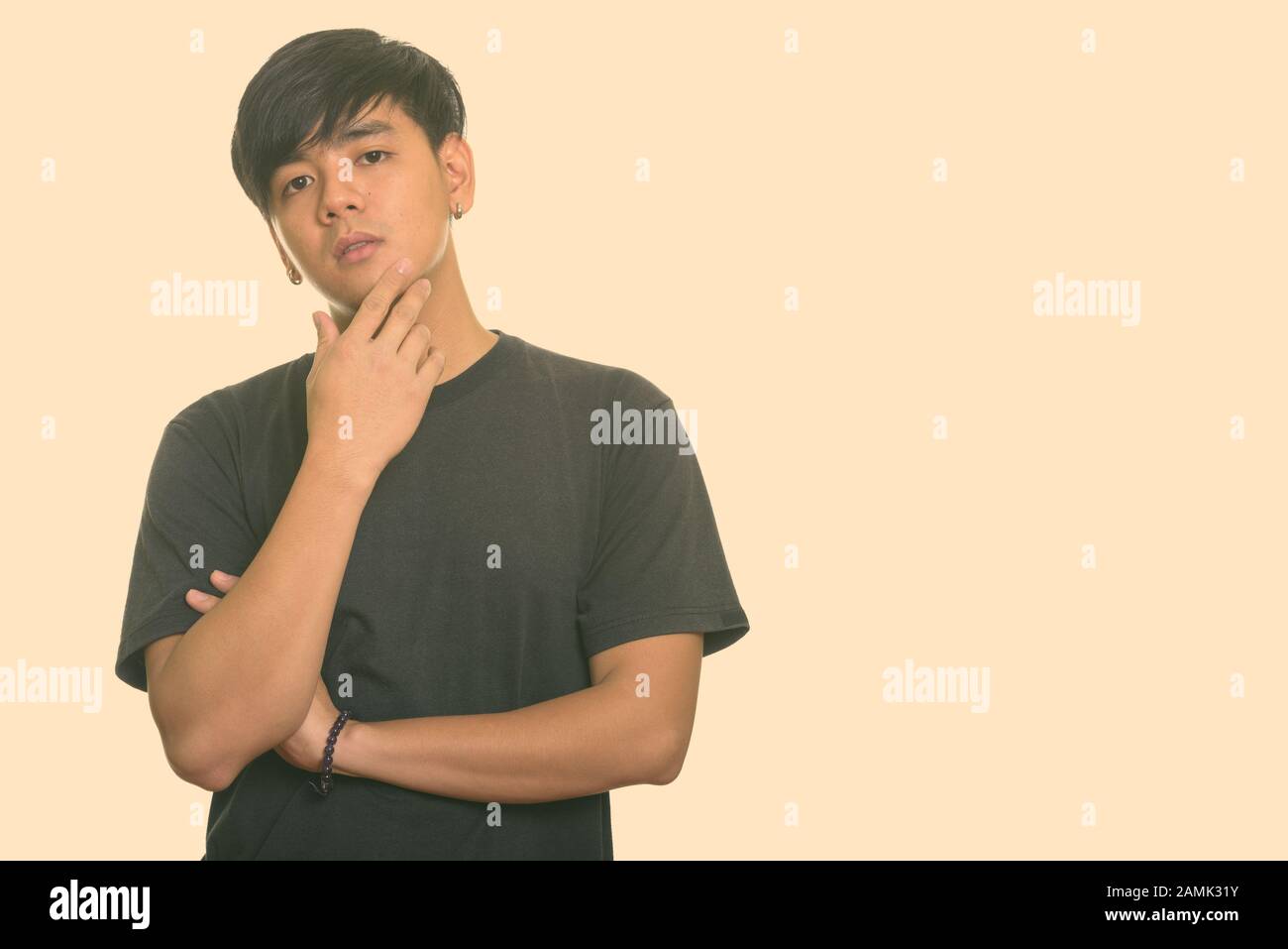 Studio shot of young handsome Filipino man isolated against white ...