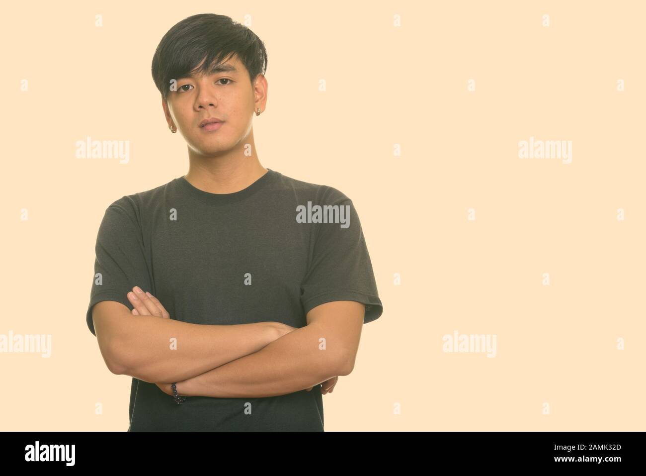 Studio shot of young handsome Filipino man isolated against white ...