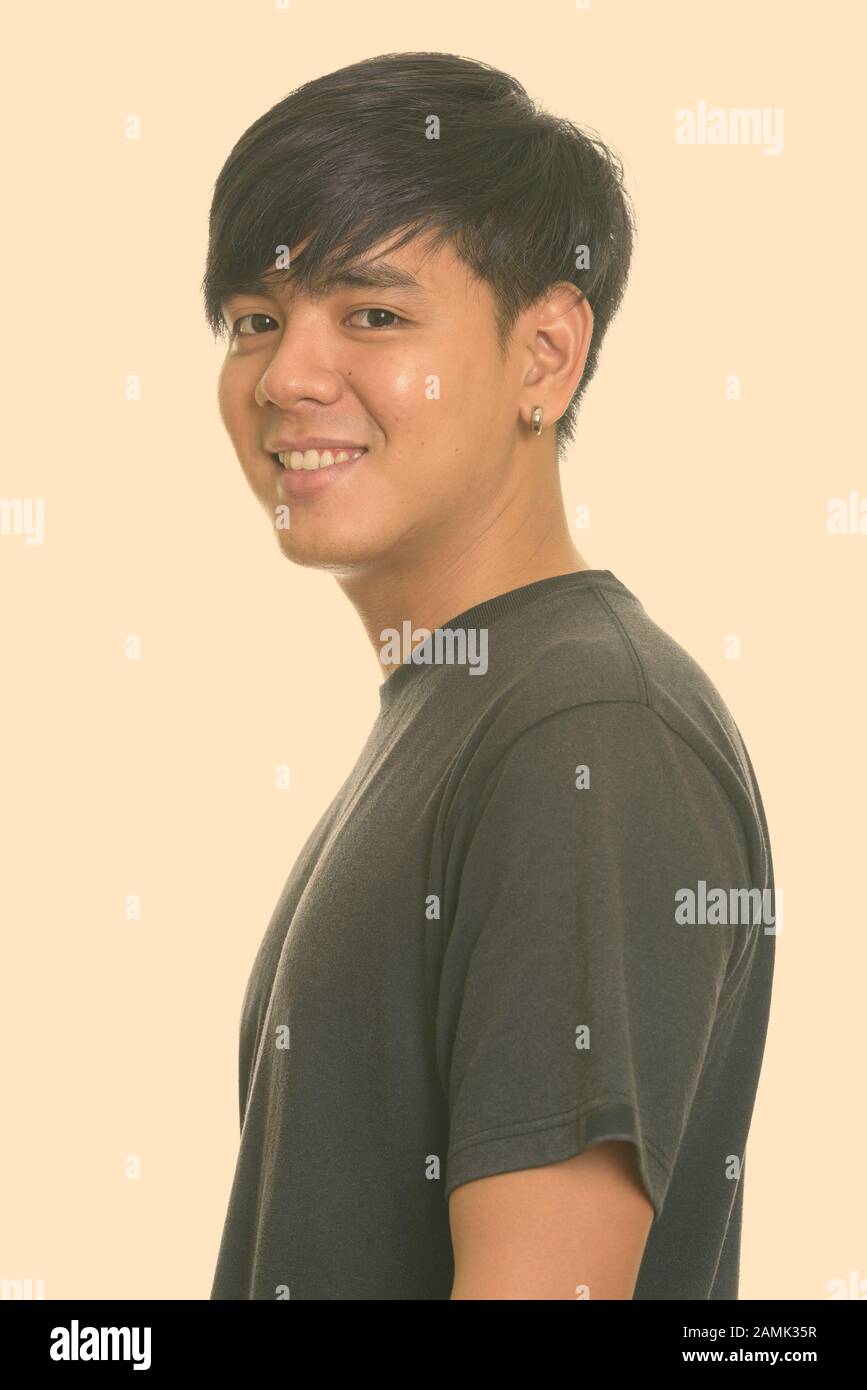Studio shot of young handsome Filipino man isolated against white ...