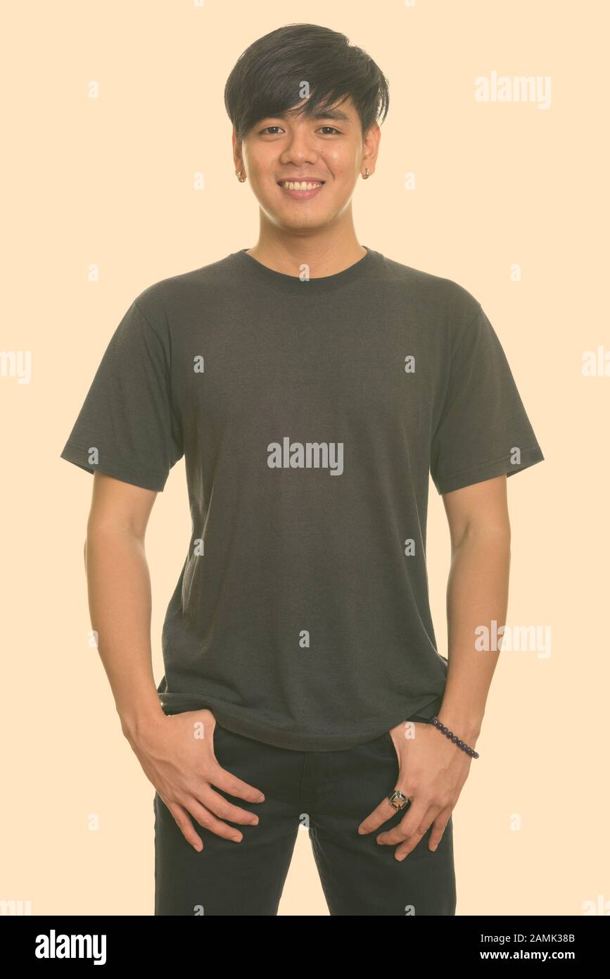 Studio shot of young handsome Filipino man isolated against white ...