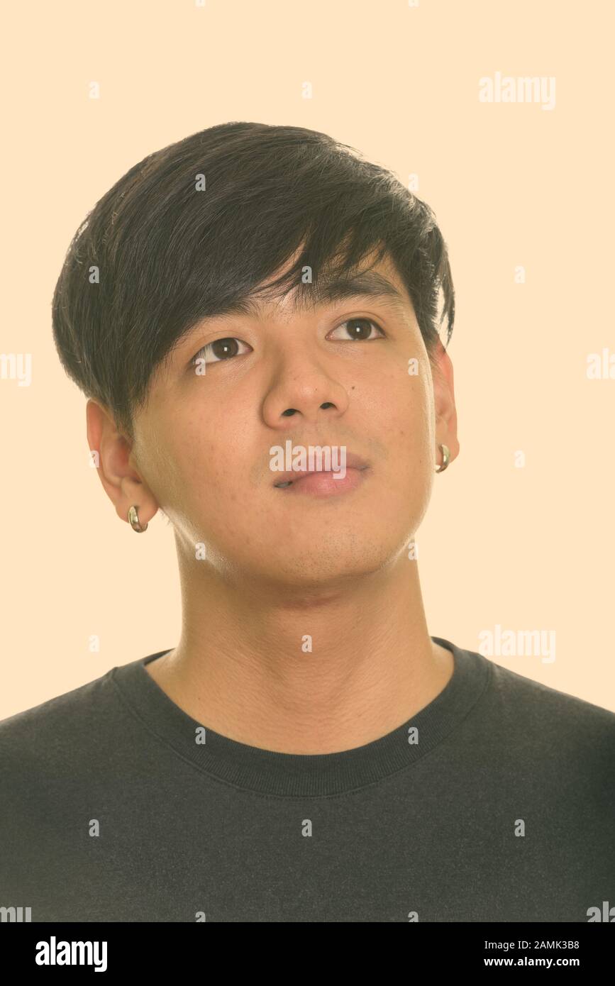 Studio shot of young handsome Filipino man isolated against white ...