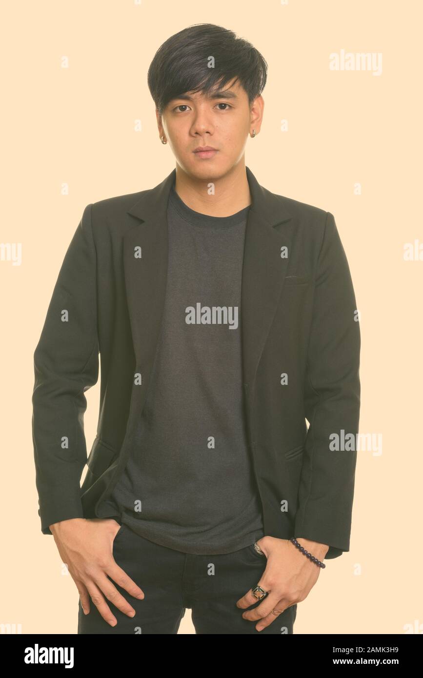 Studio shot of young handsome Filipino man isolated against white ...