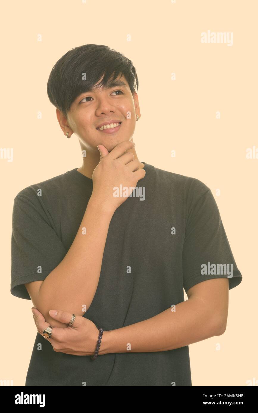 Studio shot of young handsome Filipino man isolated against white ...