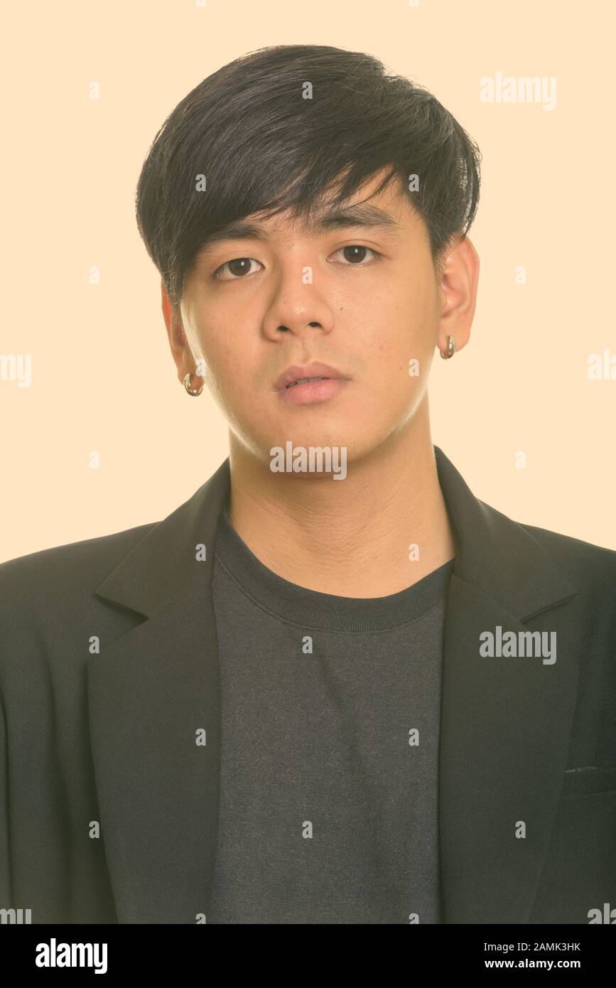 Studio shot of young handsome Filipino man isolated against white ...