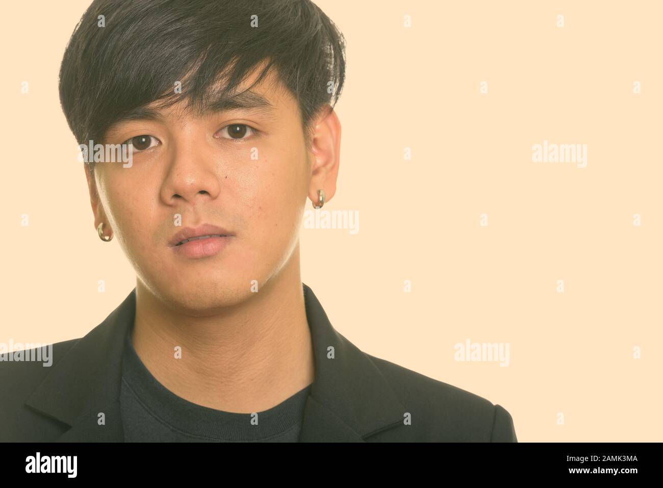 Studio shot of young handsome Filipino man isolated against white ...