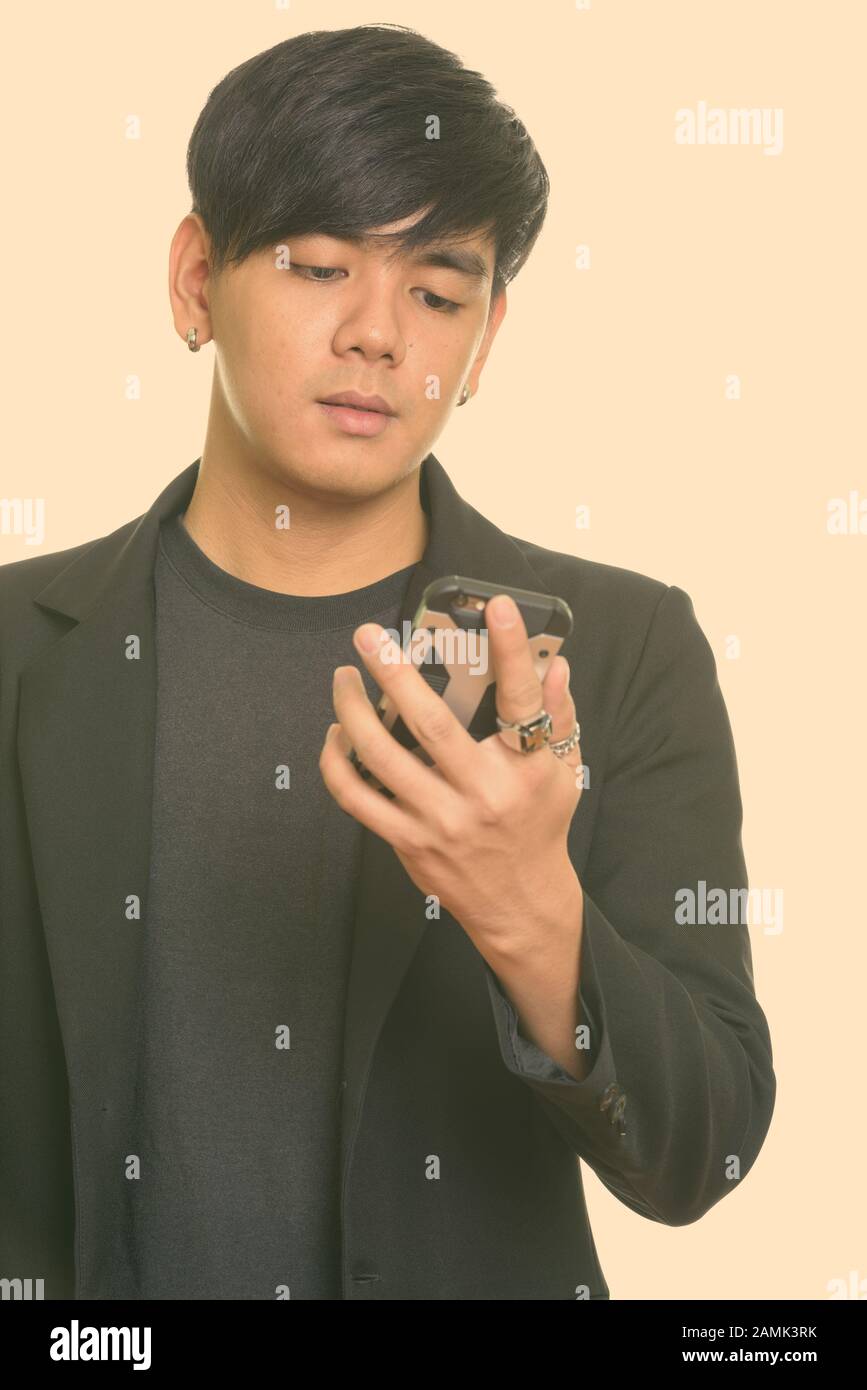 Studio shot of young handsome Filipino man isolated against white ...