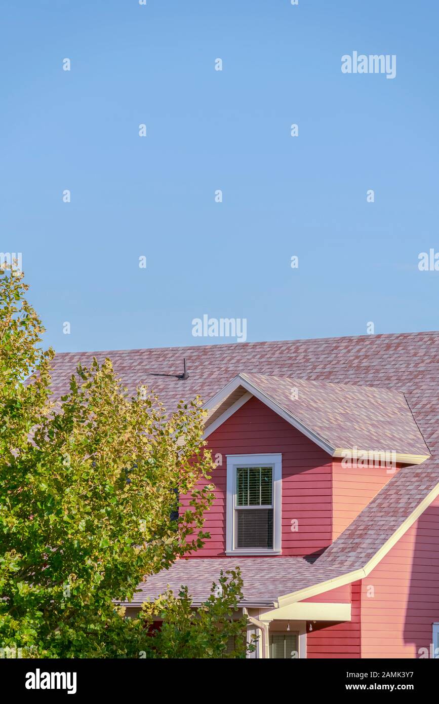 Colourful red timber clad house in green trees Stock Photo - Alamy
