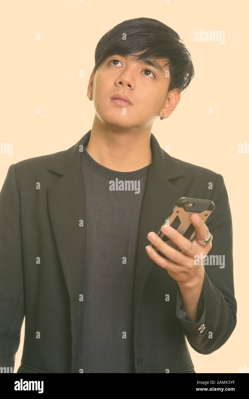 Studio shot of young handsome Filipino man isolated against white ...