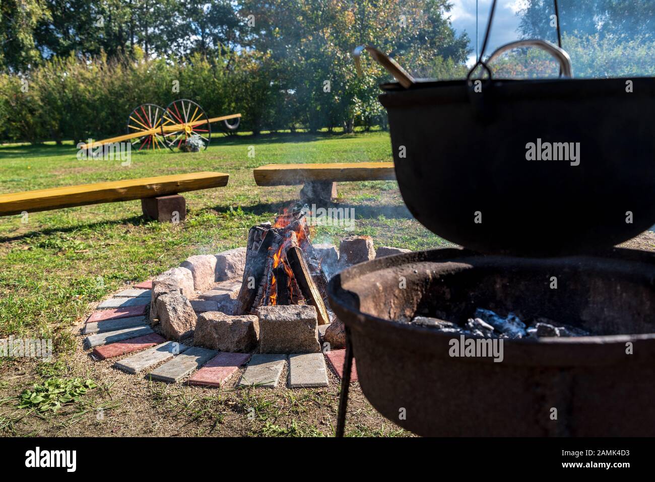 Cooking food in a big black kettle on fire outside Stock Photo - Alamy