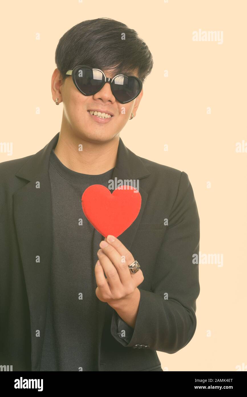 Studio shot of young handsome Filipino man isolated against white ...