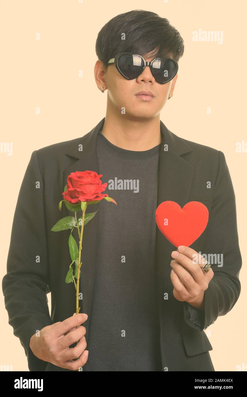 Studio shot of young handsome Filipino man isolated against white ...