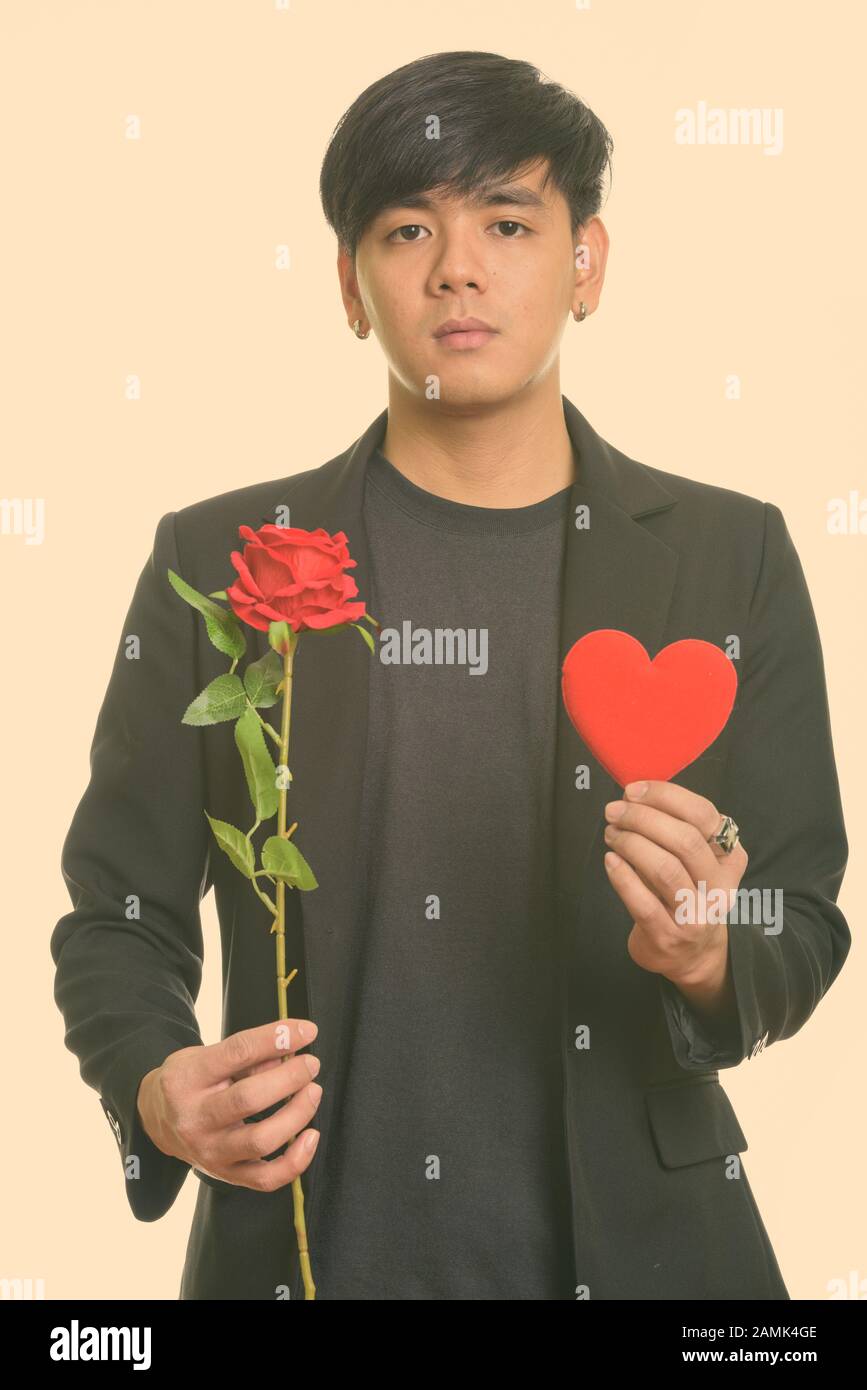 Studio shot of young handsome Filipino man isolated against white ...