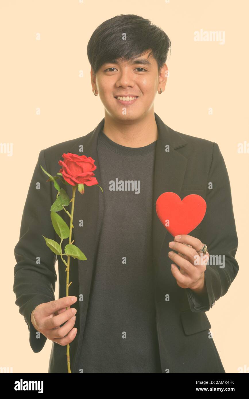 Studio shot of young handsome Filipino man isolated against white ...