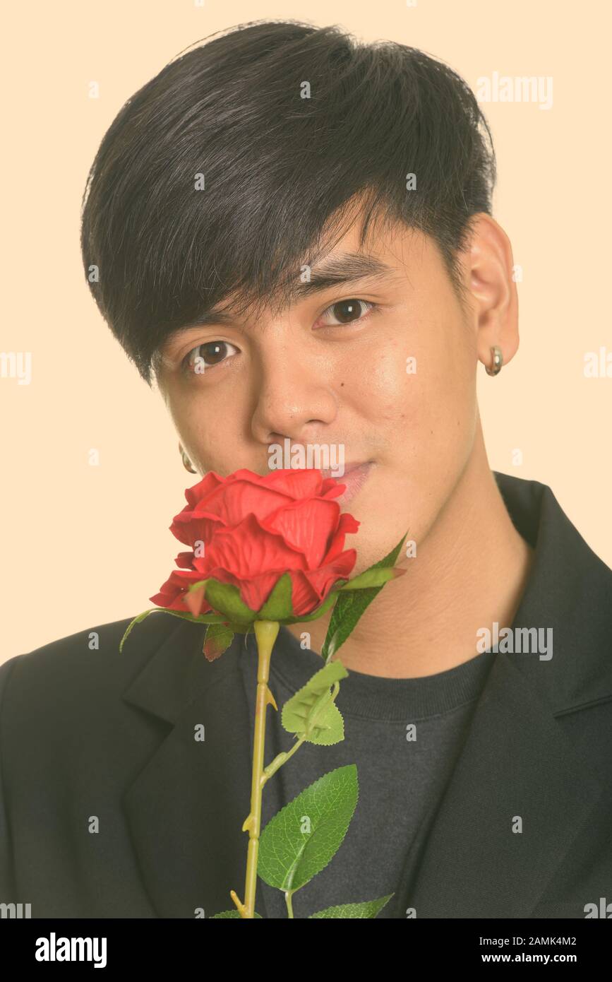 Studio shot of young handsome Filipino man isolated against white ...