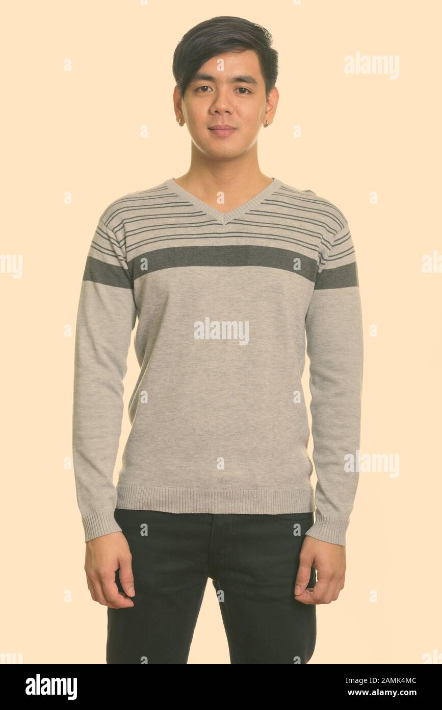 Studio shot of young handsome Filipino man isolated against white ...