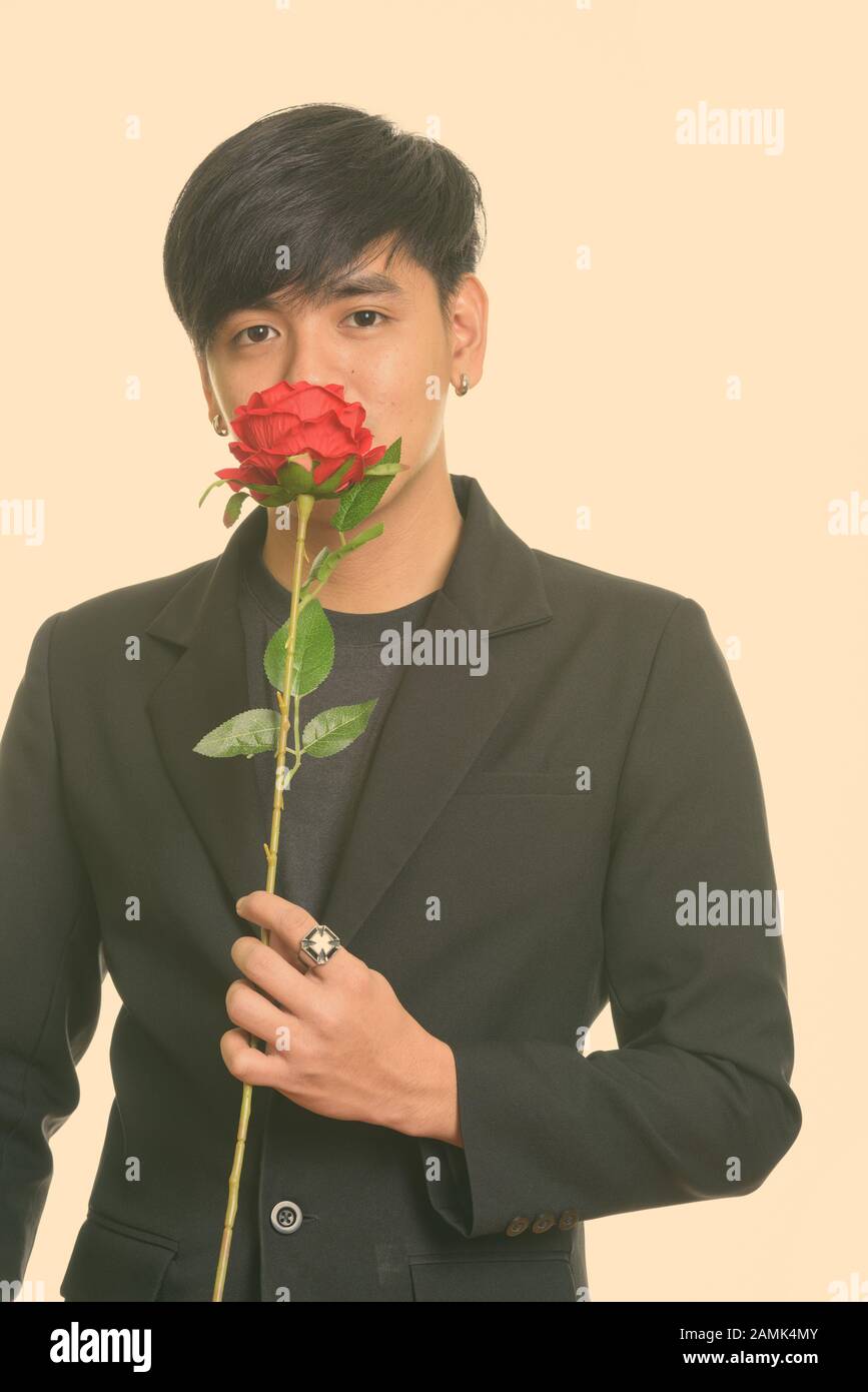 Studio shot of young handsome Filipino man isolated against white ...