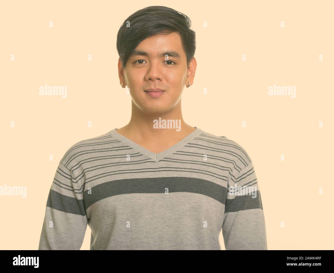 Studio shot of young handsome Filipino man isolated against white ...