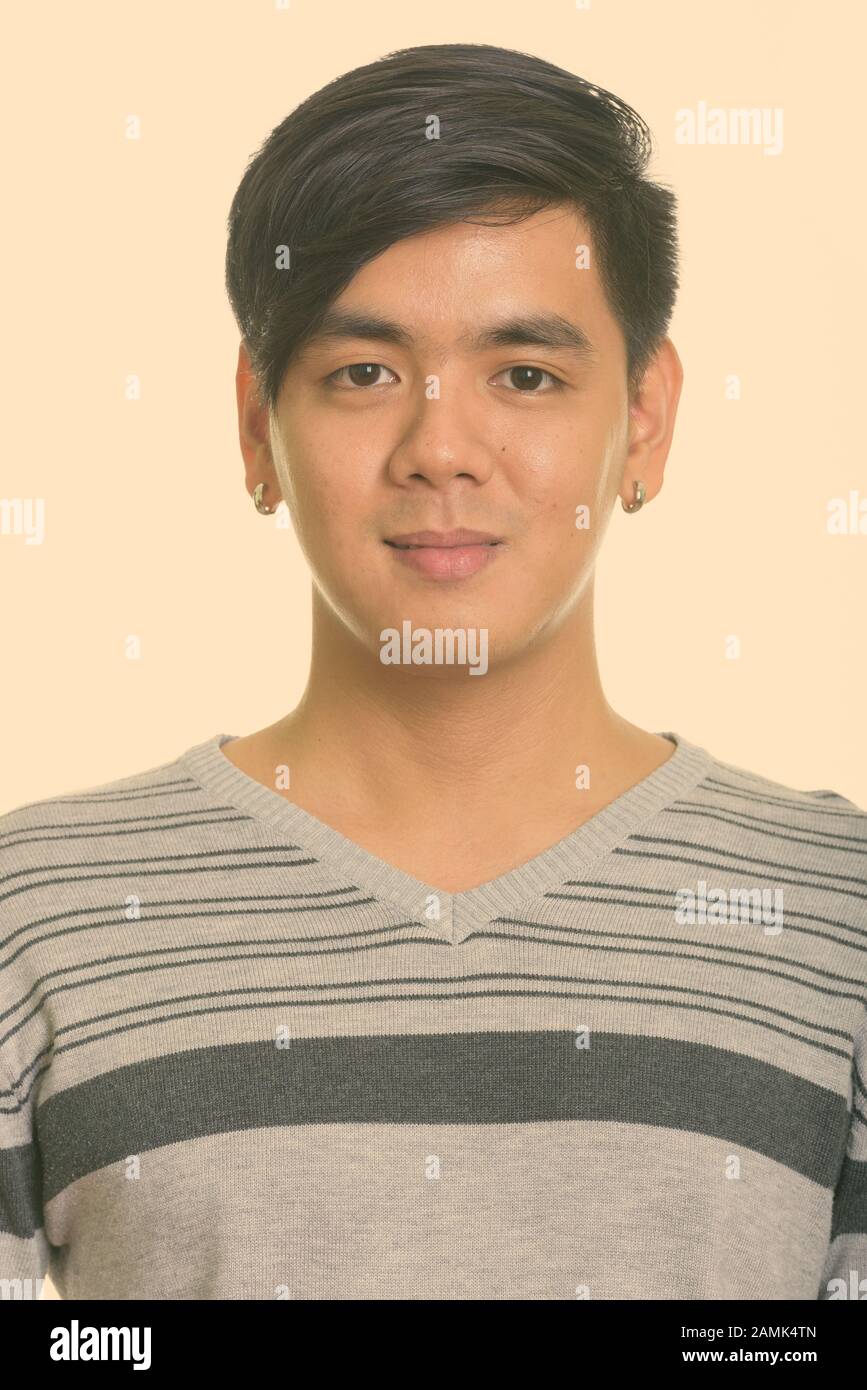 Studio shot of young handsome Filipino man isolated against white ...