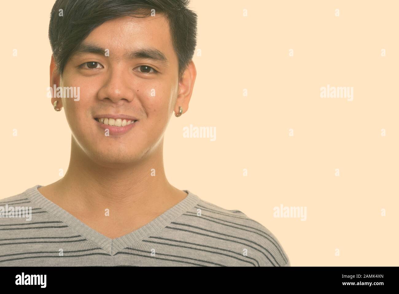 Studio shot of young handsome Filipino man isolated against white ...