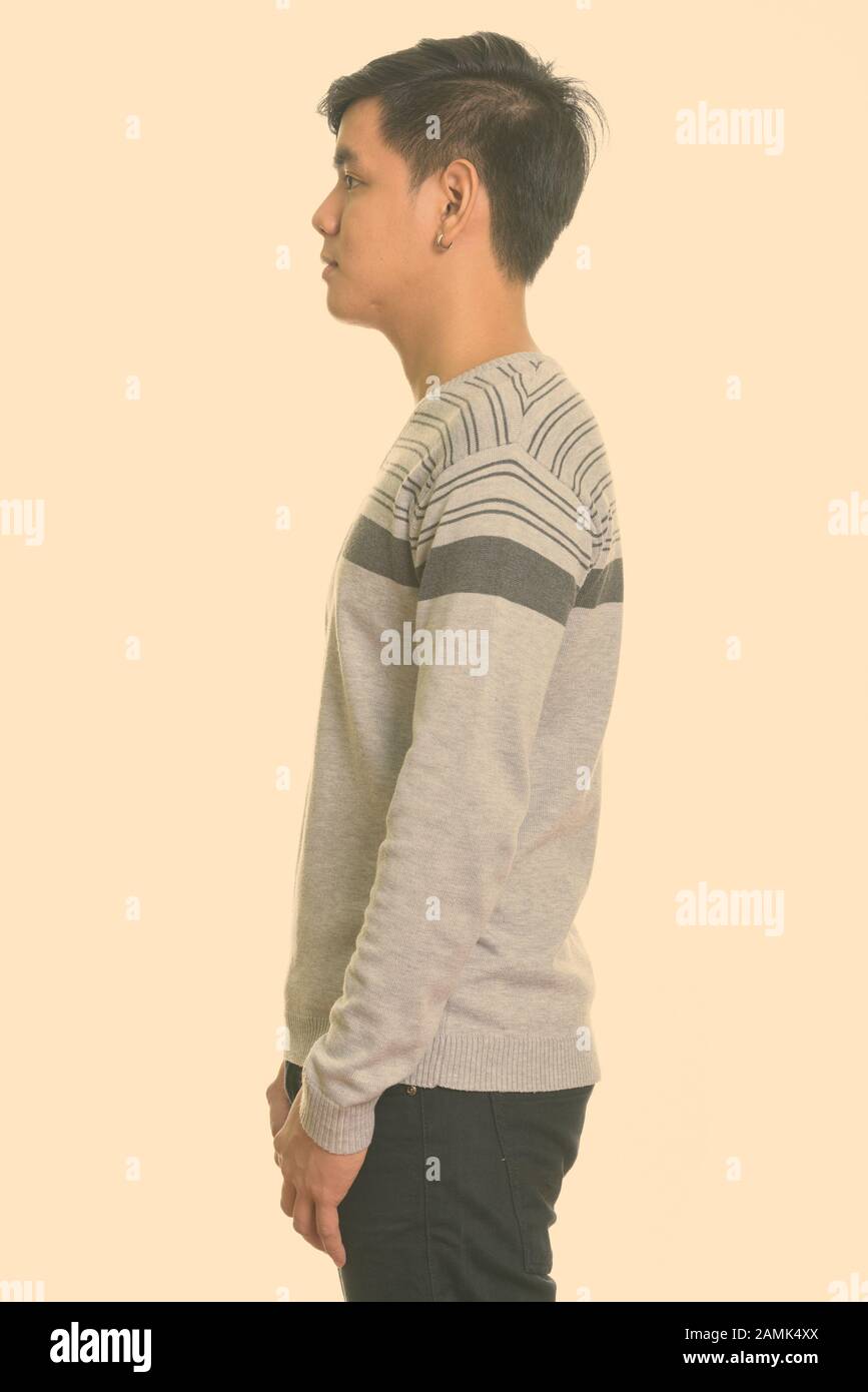 Studio shot of young handsome Filipino man isolated against white ...