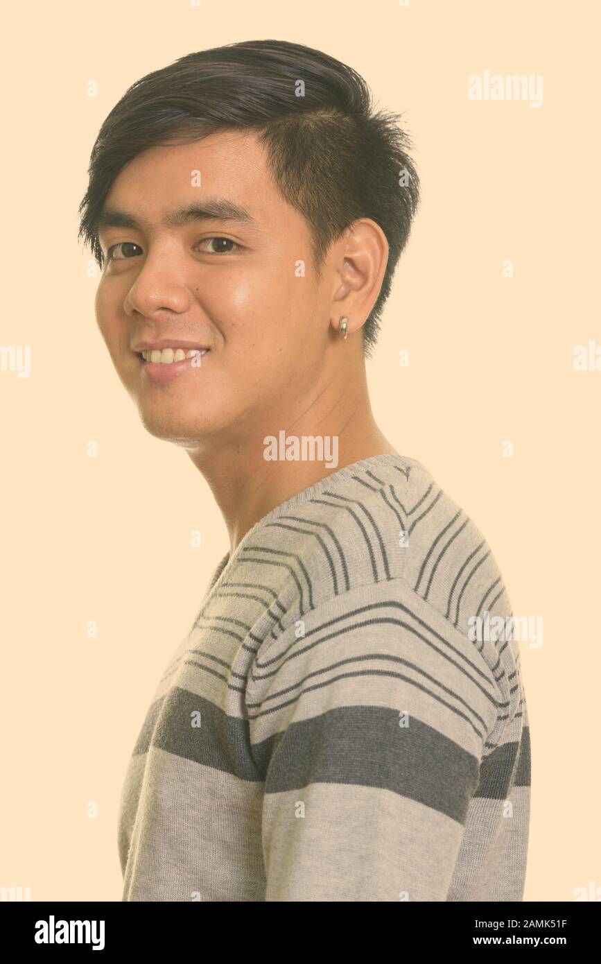 Studio shot of young handsome Filipino man isolated against white ...