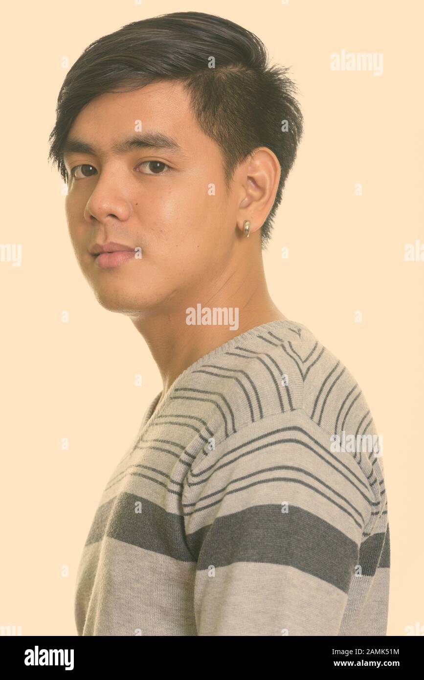 Studio shot of young handsome Filipino man isolated against white ...