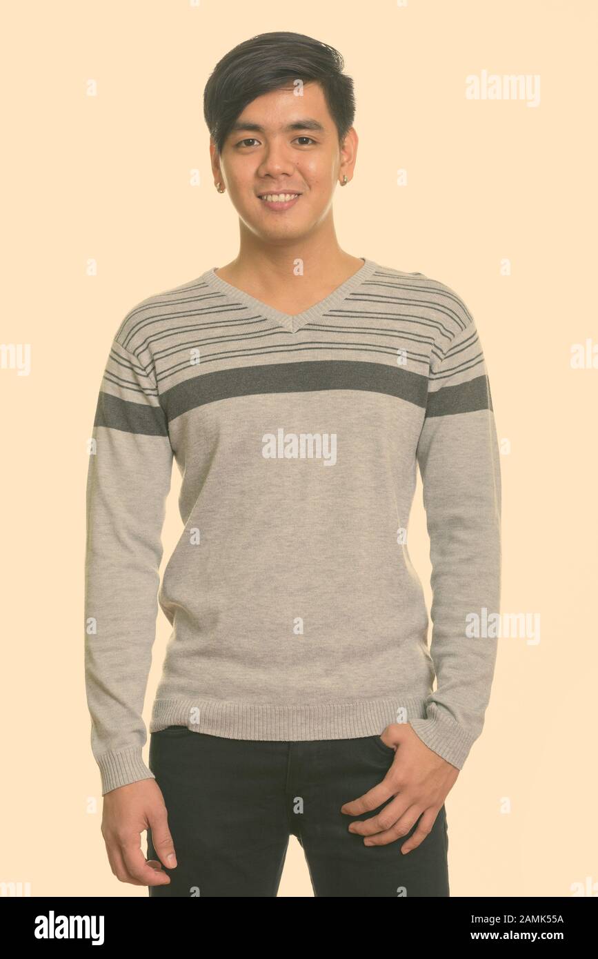 Studio shot of young handsome Filipino man isolated against white ...
