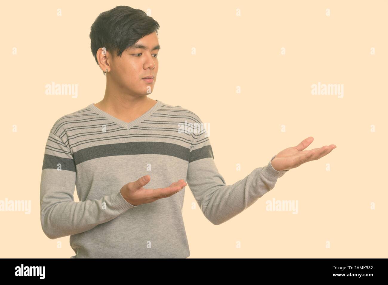 Studio shot of young handsome Filipino man isolated against white ...