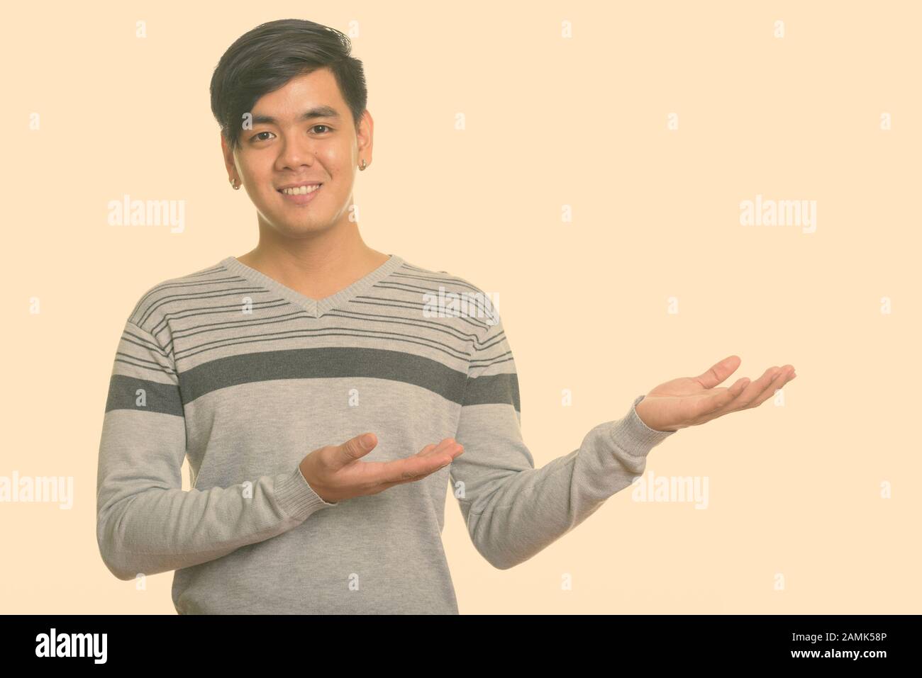 Studio shot of young handsome Filipino man isolated against white ...