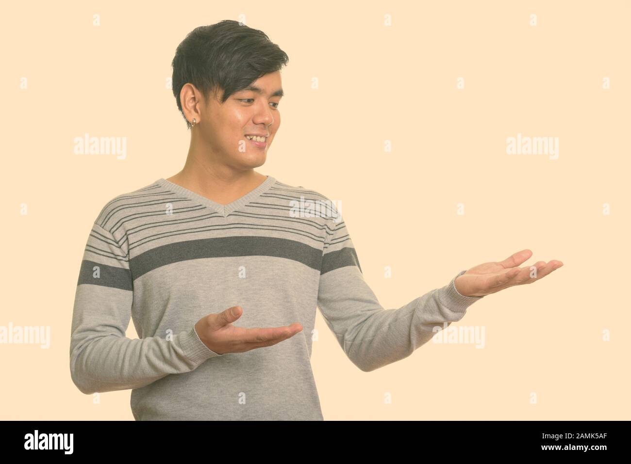 Studio shot of young handsome Filipino man isolated against white ...