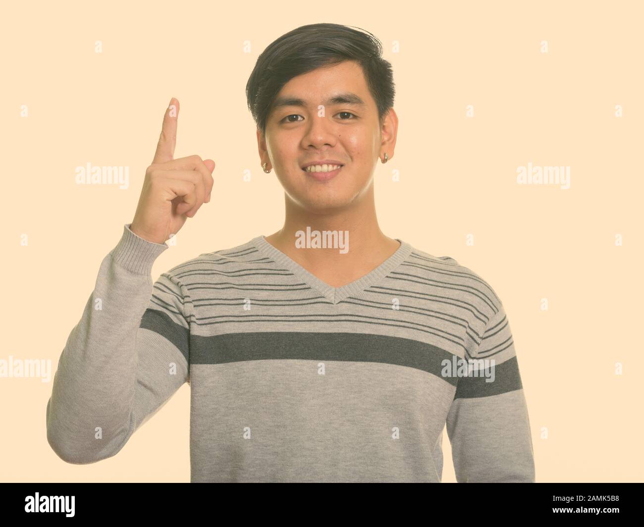 Studio shot of young handsome Filipino man isolated against white ...