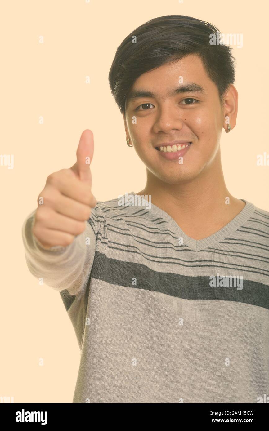 Studio shot of young handsome Filipino man isolated against white ...