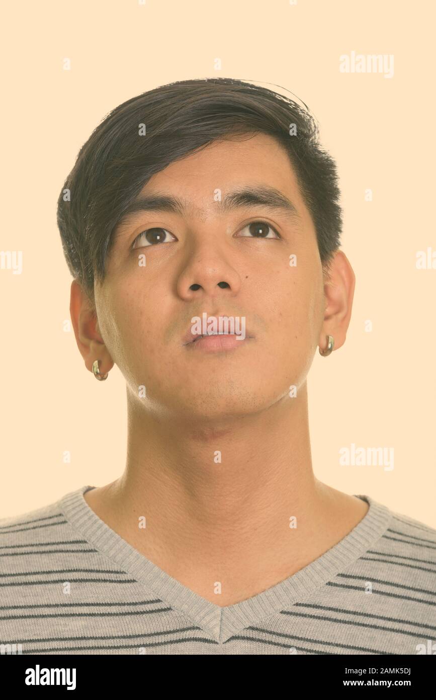 Studio shot of young handsome Filipino man isolated against white ...