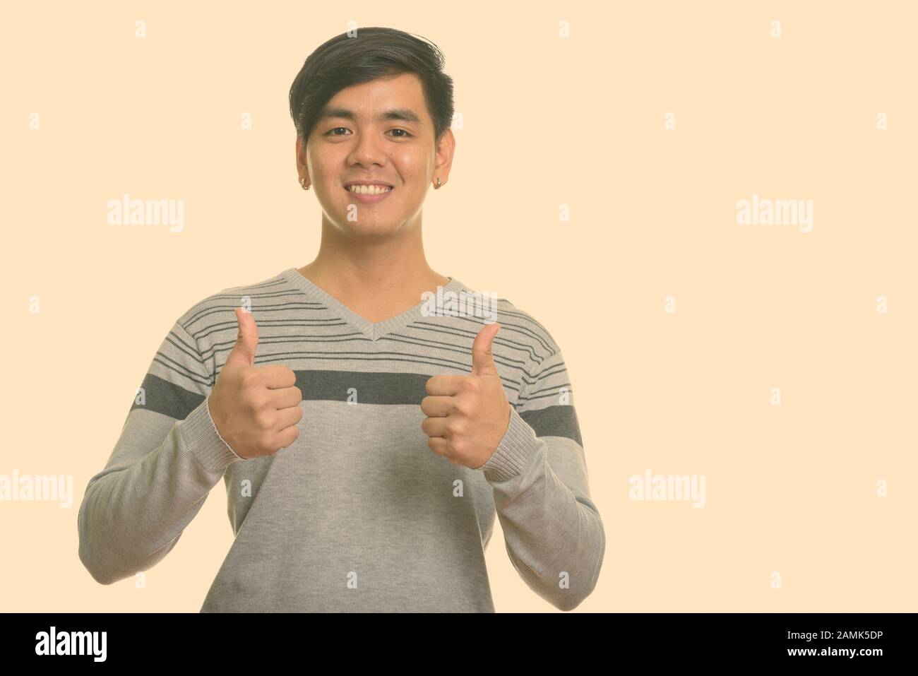 Studio shot of young handsome Filipino man isolated against white ...
