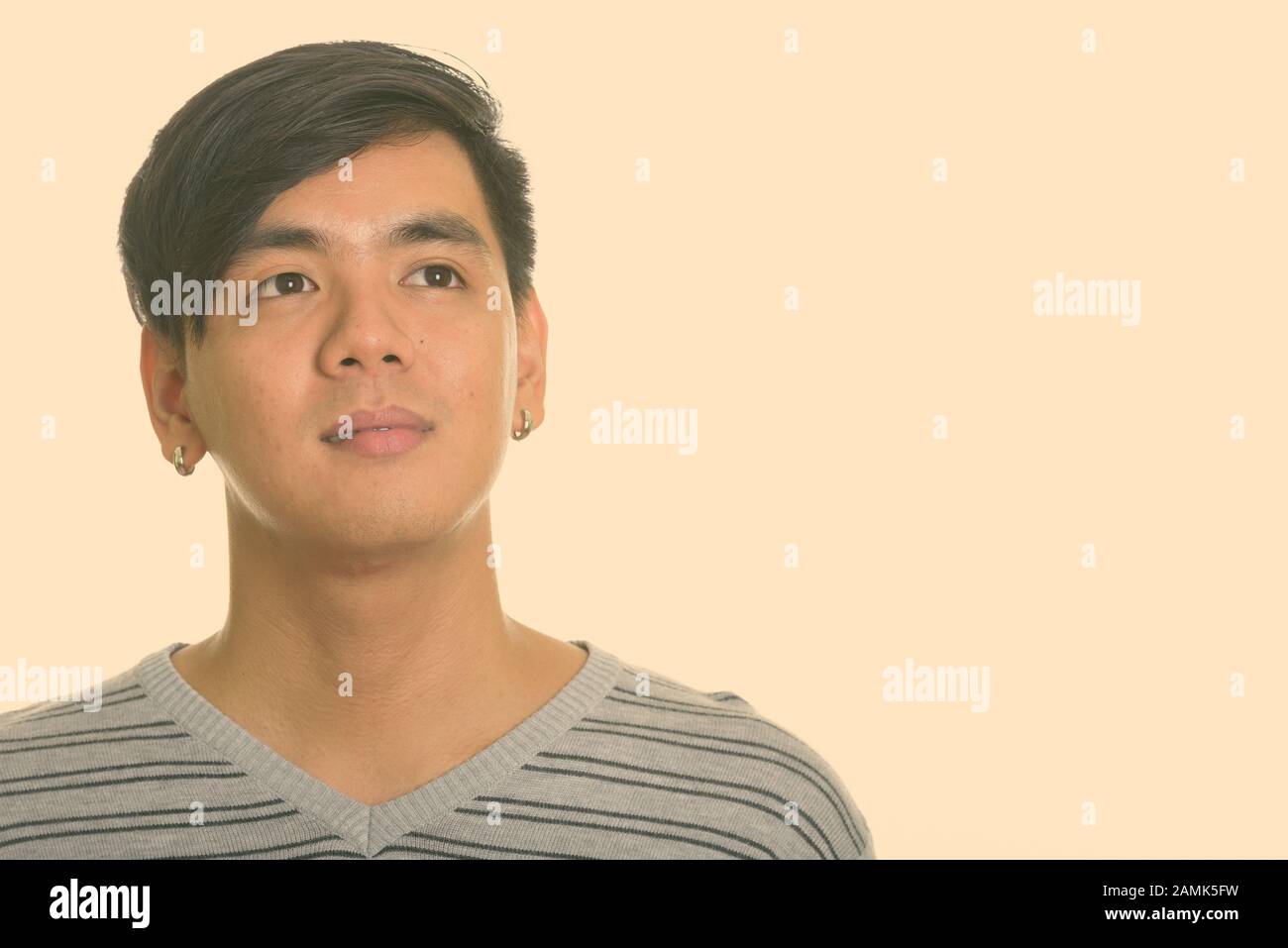 Studio shot of young handsome Filipino man isolated against white ...