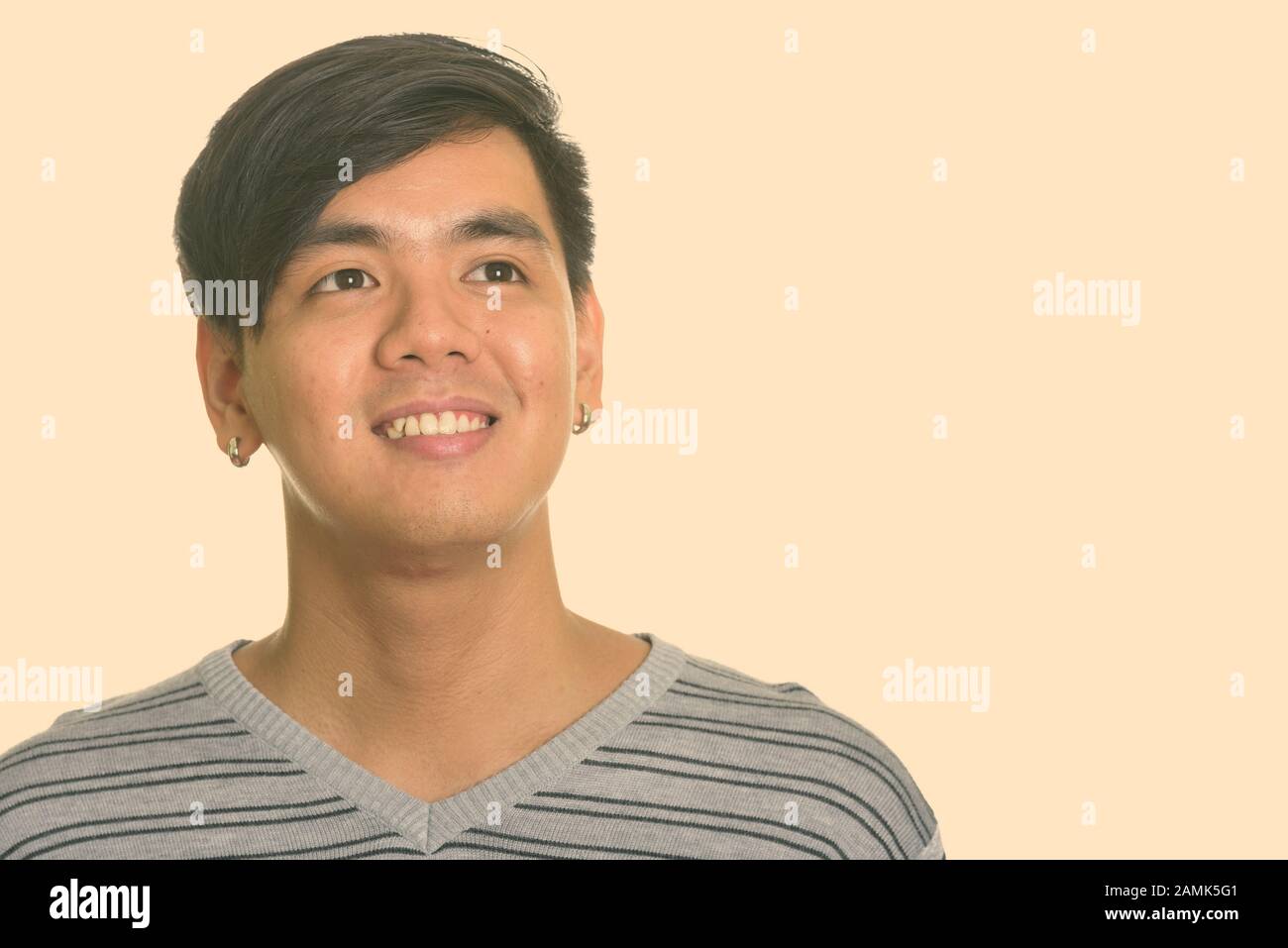 Studio shot of young handsome Filipino man isolated against white ...