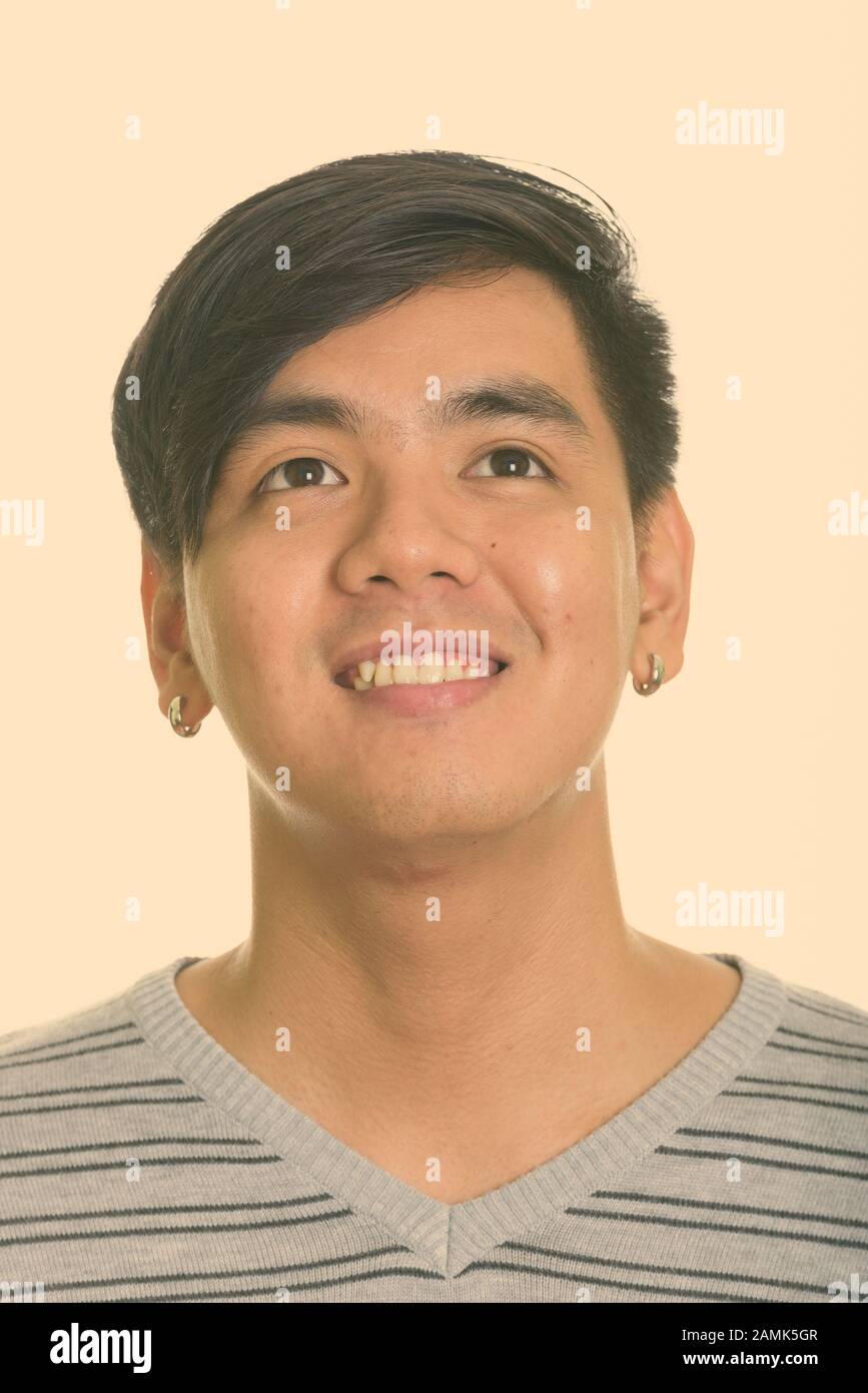 Studio shot of young handsome Filipino man isolated against white ...