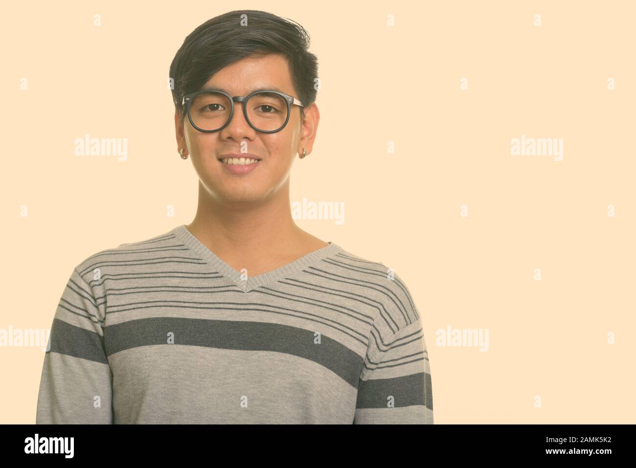 Studio shot of young handsome Filipino man isolated against white ...