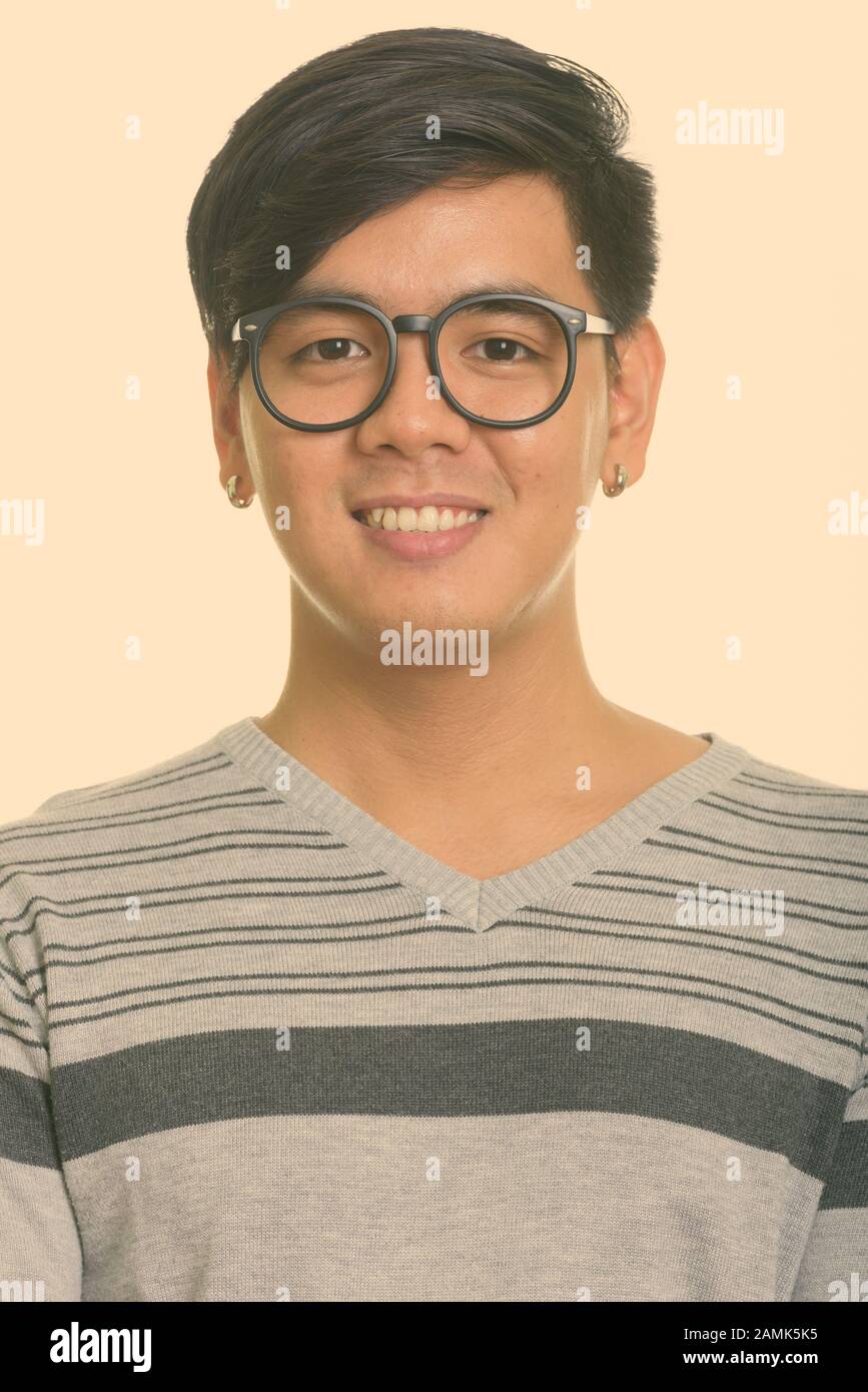 Studio shot of young handsome Filipino man isolated against white ...