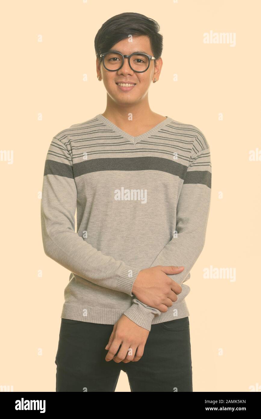 Studio shot of young handsome Filipino man isolated against white ...
