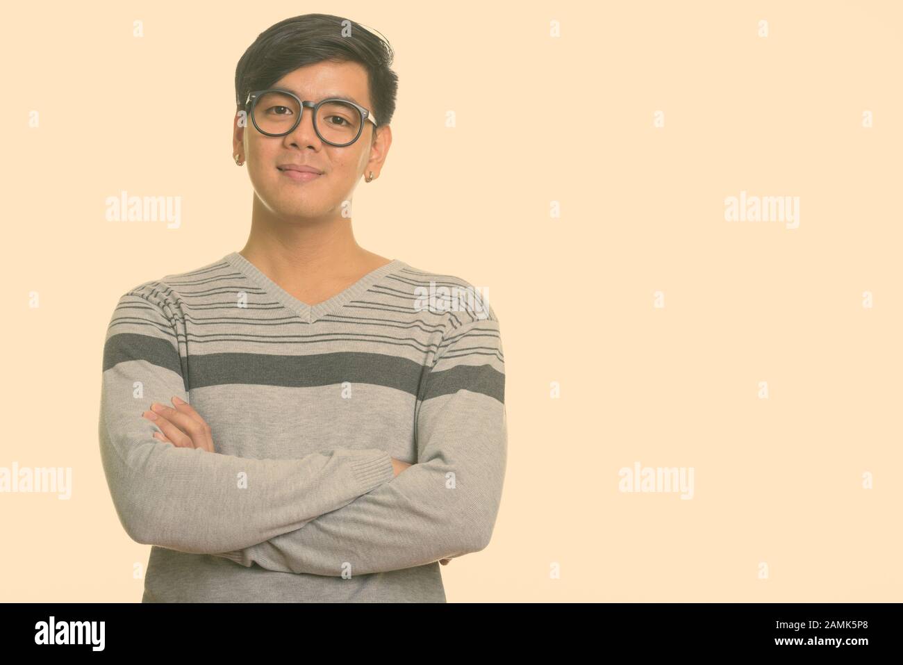 Studio shot of young handsome Filipino man isolated against white ...