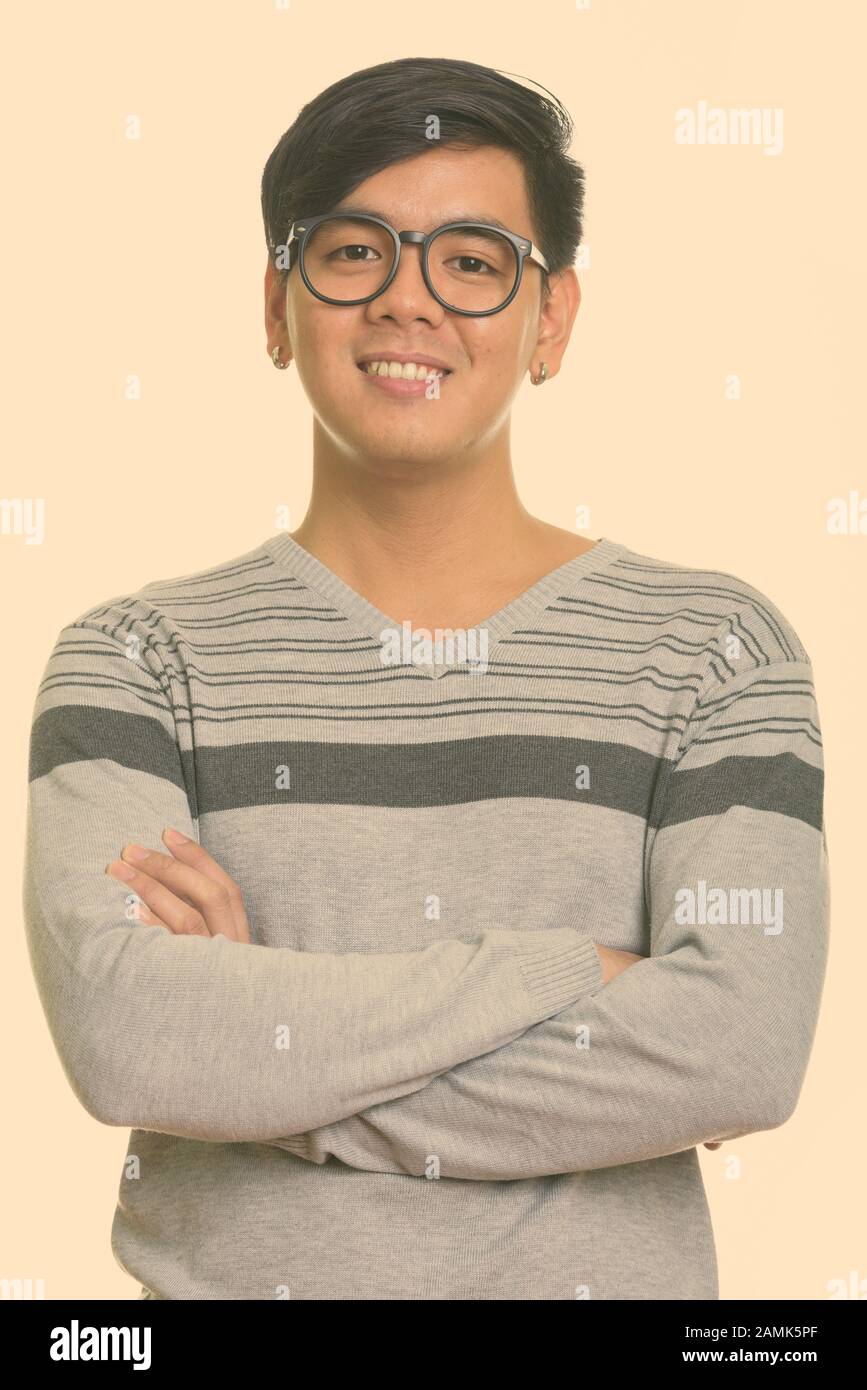 Studio shot of young handsome Filipino man isolated against white ...
