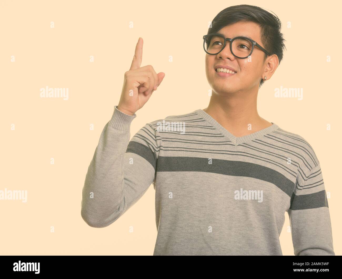 Studio shot of young handsome Filipino man isolated against white ...