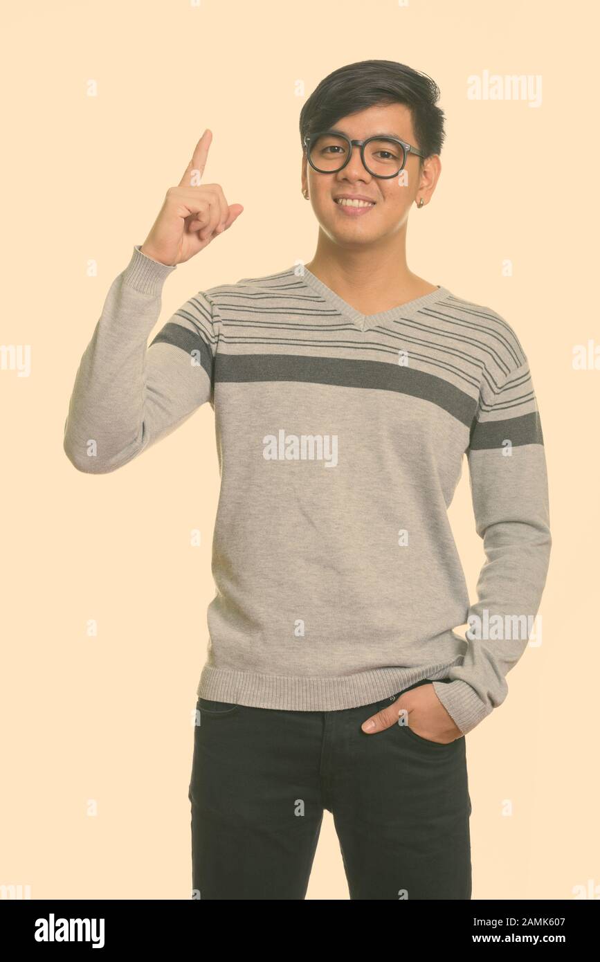 Studio shot of young handsome Filipino man isolated against white ...