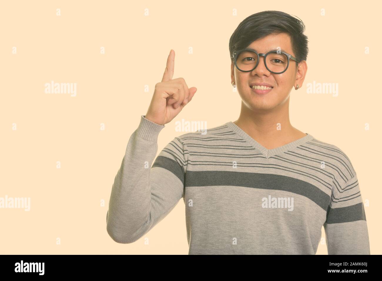 Studio shot of young handsome Filipino man isolated against white ...