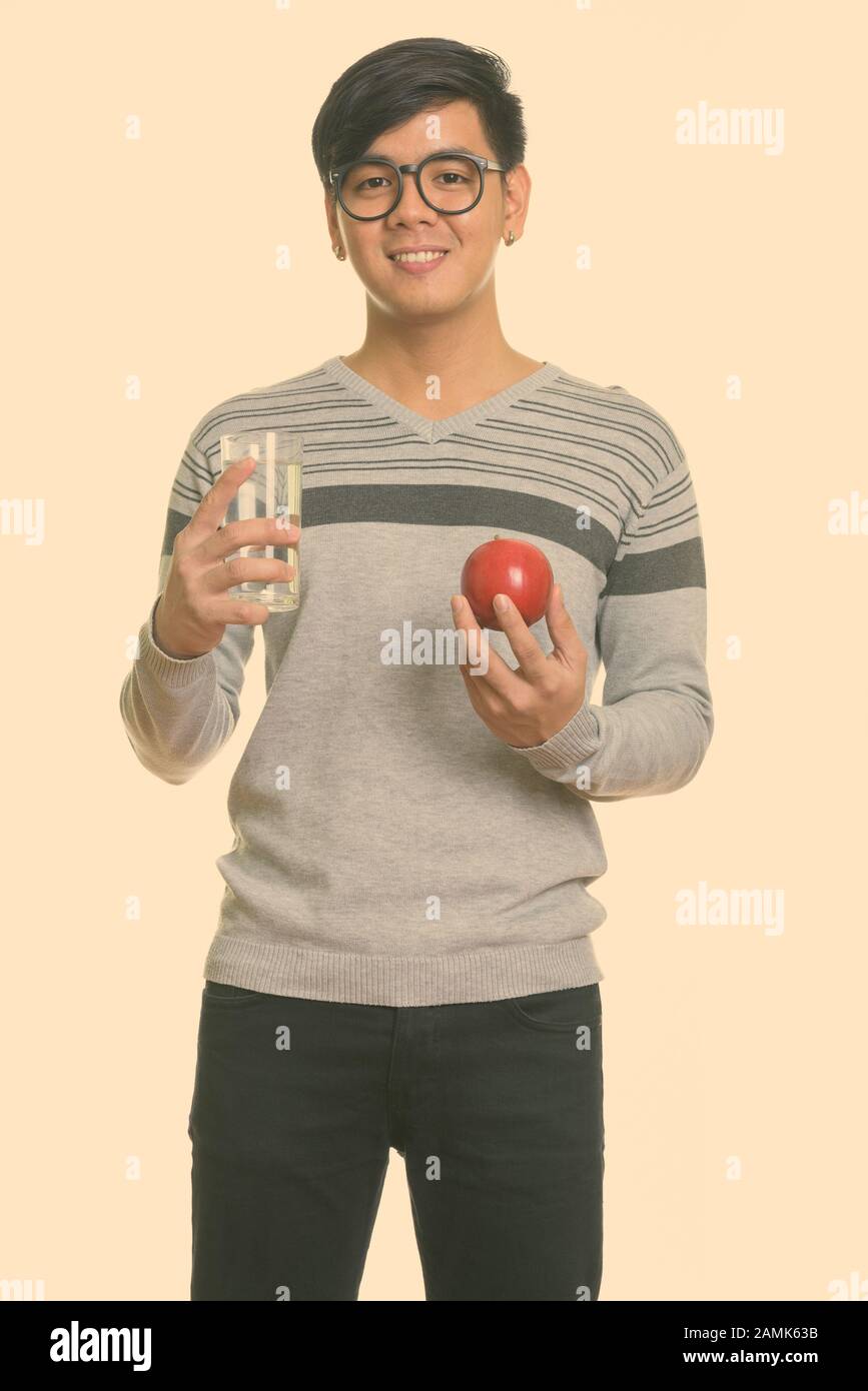 Studio shot of young handsome Filipino man isolated against white ...